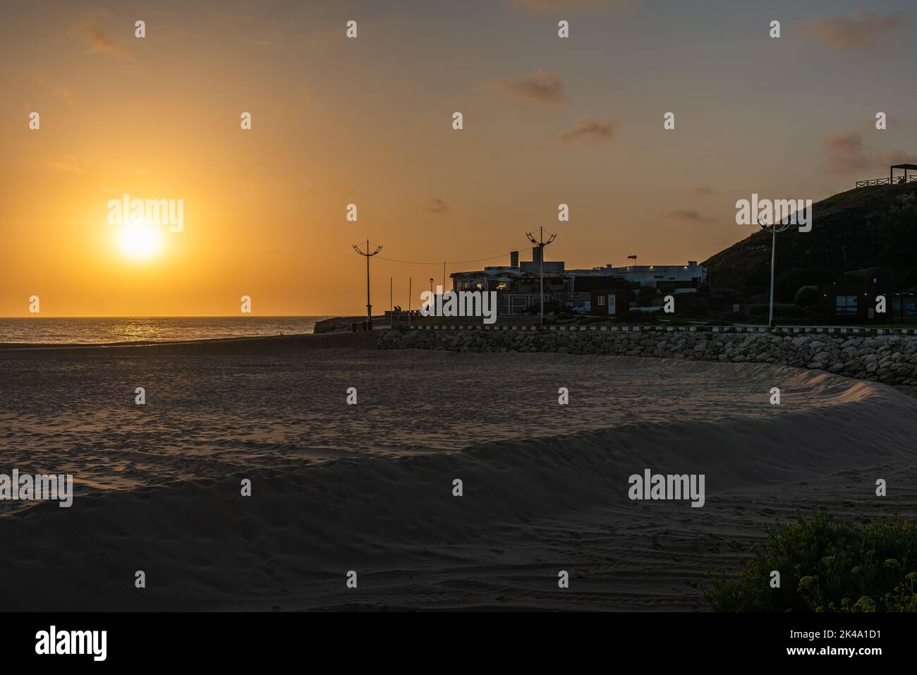 A scenic golden sunset at Areia Branca Beach in Lourinha, Portugal ...