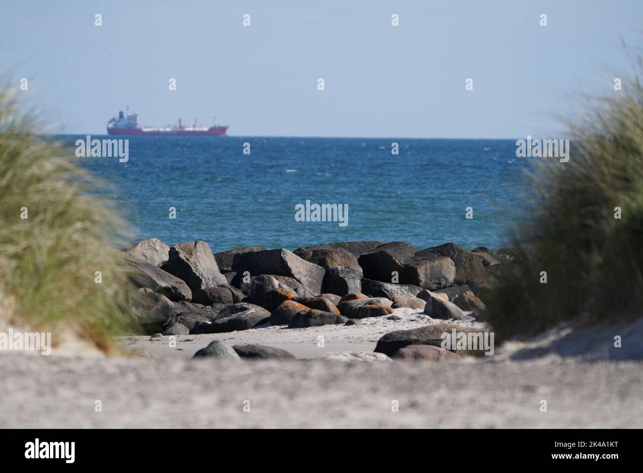 A beautiful view of rocks on a shore of a sea with ship Stock Photo - Alamy