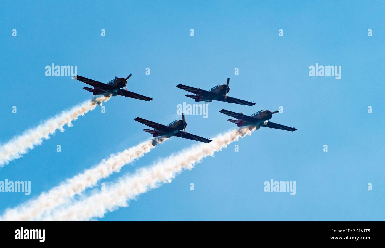 Silhouettes of training aircraft performing aerobatics on a clear sunny ...