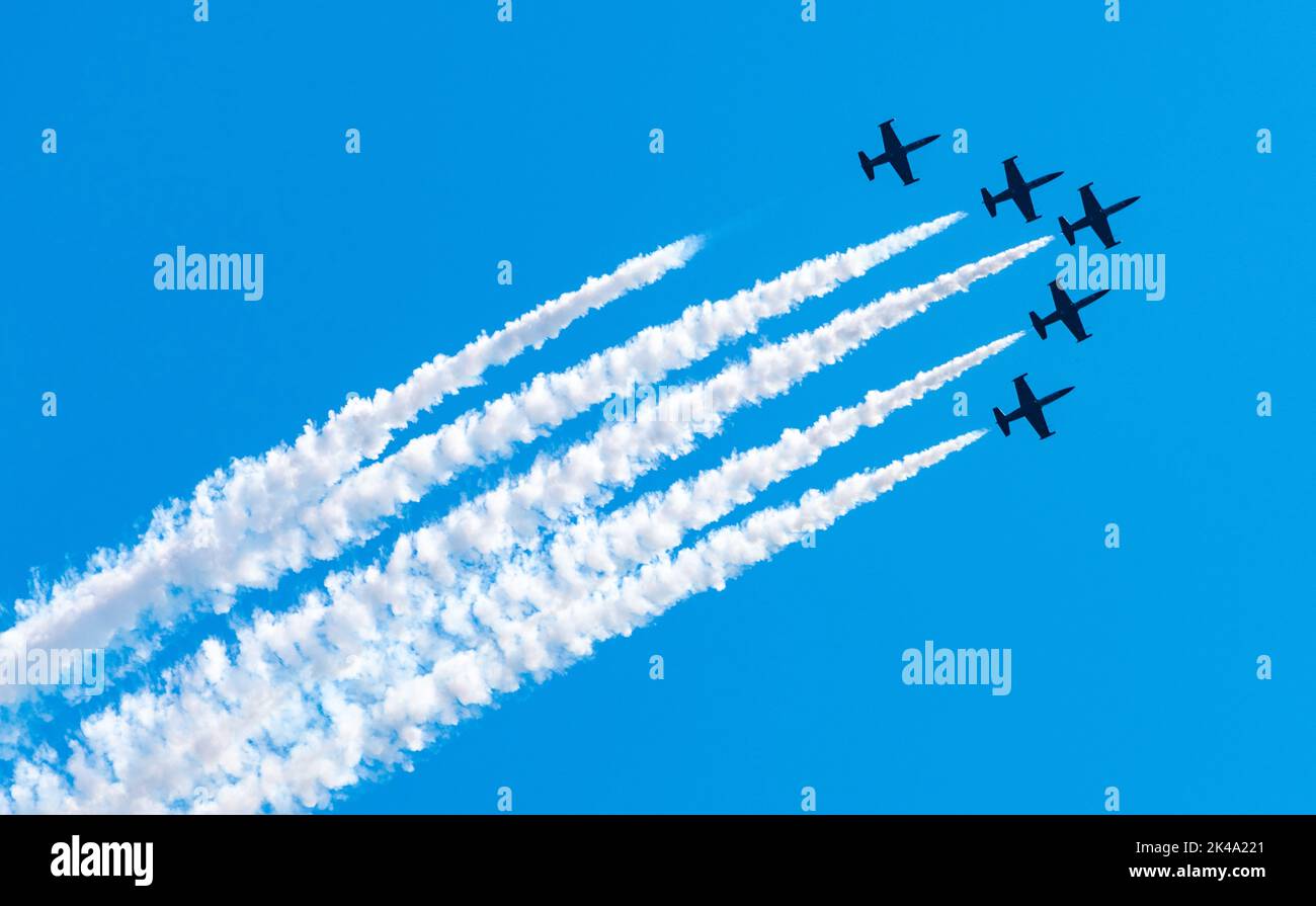 Silhouettes of training aircraft performing aerobatics on a clear sunny ...