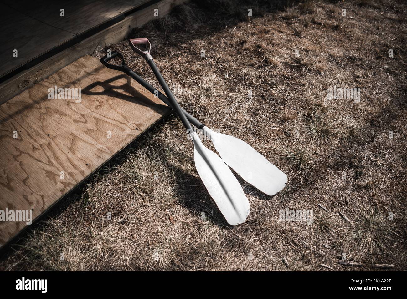 pair of oars paddles on the ground leaning on the wooden step next to ...