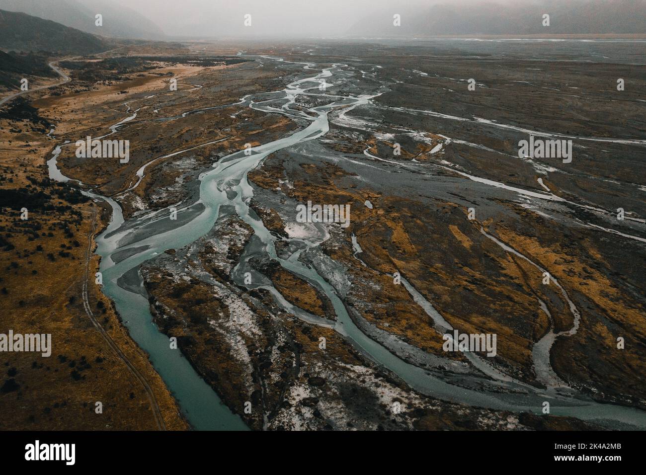 many narrow meanders forming curved lines crossing the dark plain near ...