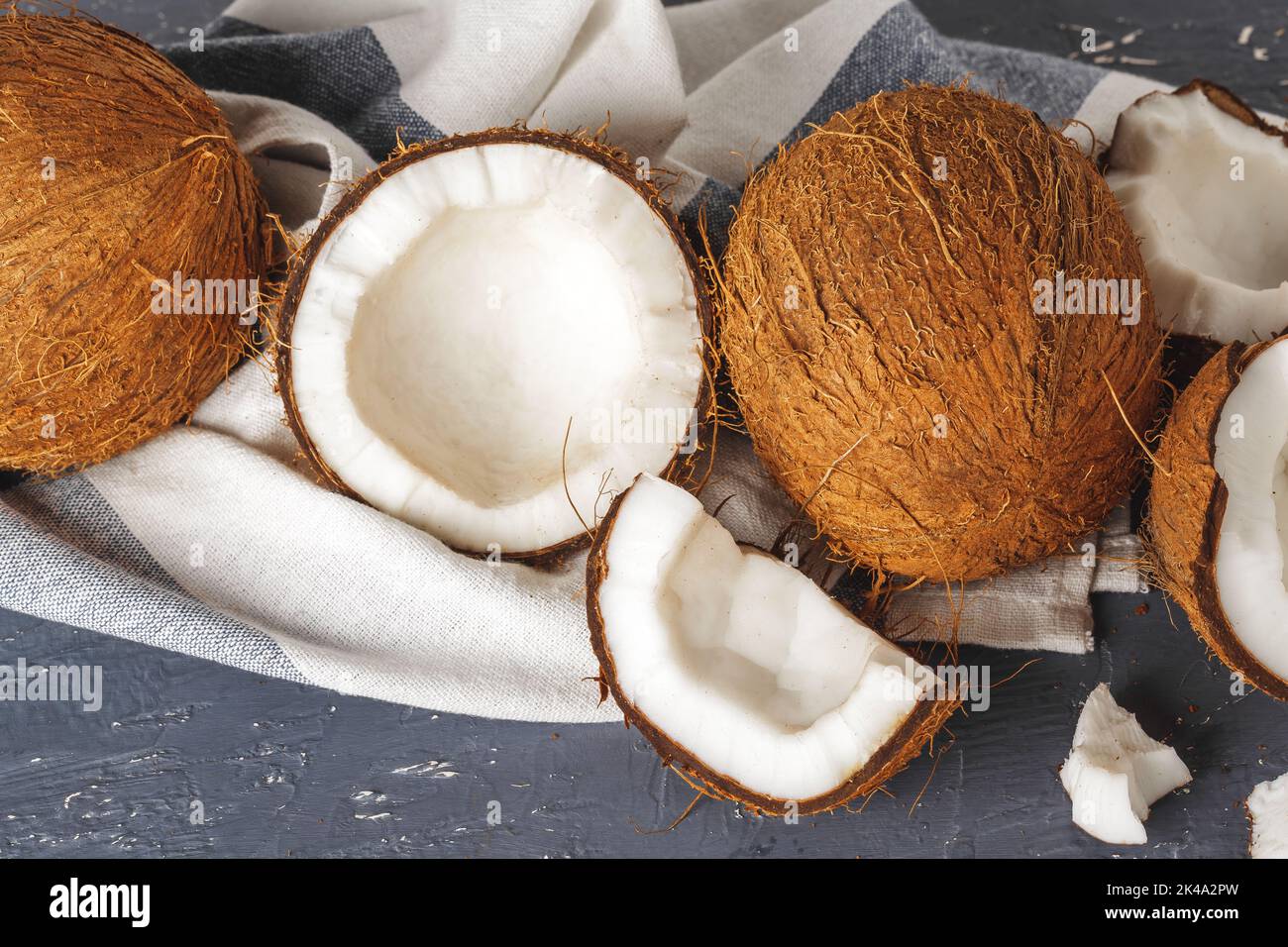 Pile of broken coconuts on ripped grey background Stock Photo - Alamy