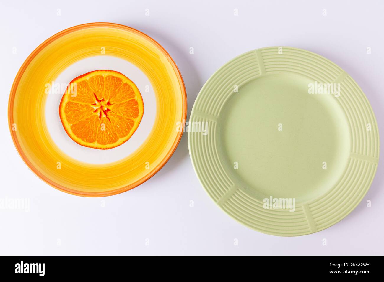 A set of old plates with drawing of an orange and another green square ...