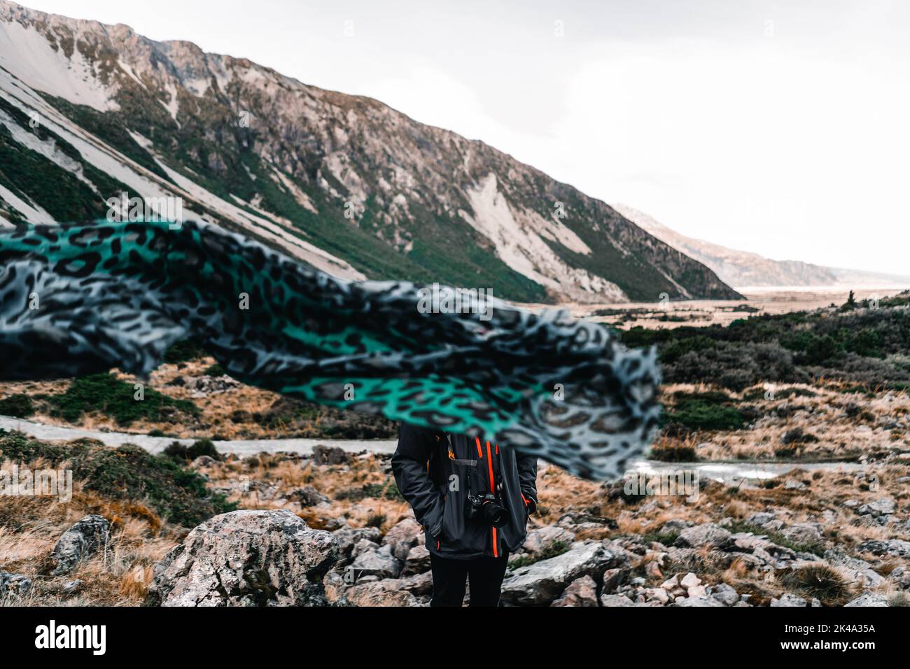 photographer with the camera slung over his shoulder and his hands in ...