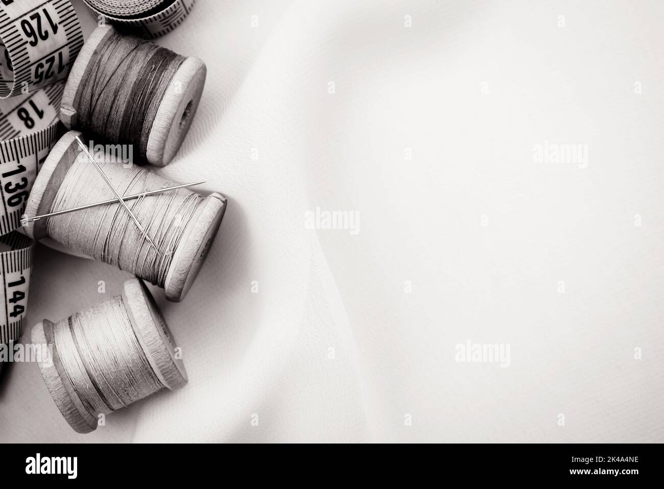 Retro needle and thread lie on the fabric. Tools for a tailor or ...