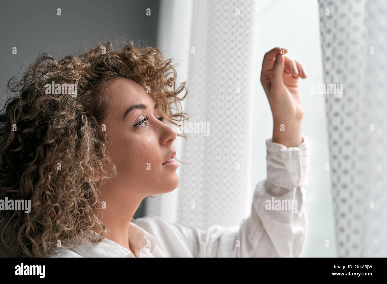 Gentle female near window in daylight Stock Photo - Alamy