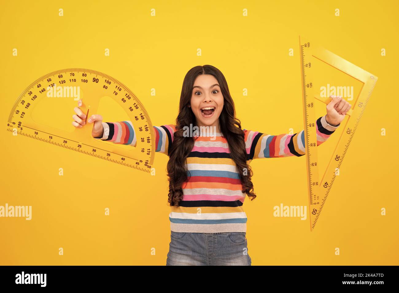 Amazed teenager. Back to school. School girl hold ruler measuring ...