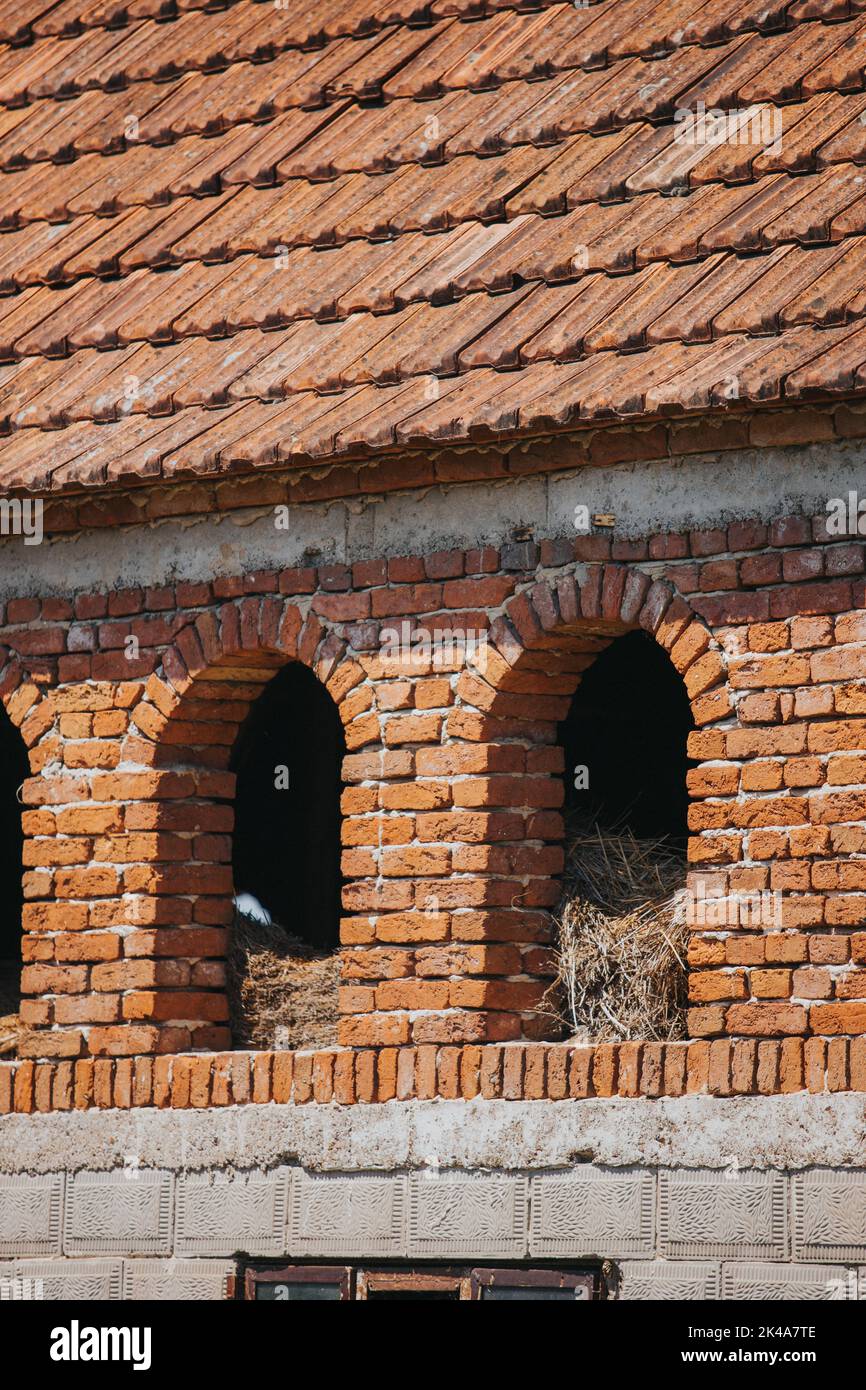An old ancient brick building with arched windows for storing hay Stock ...