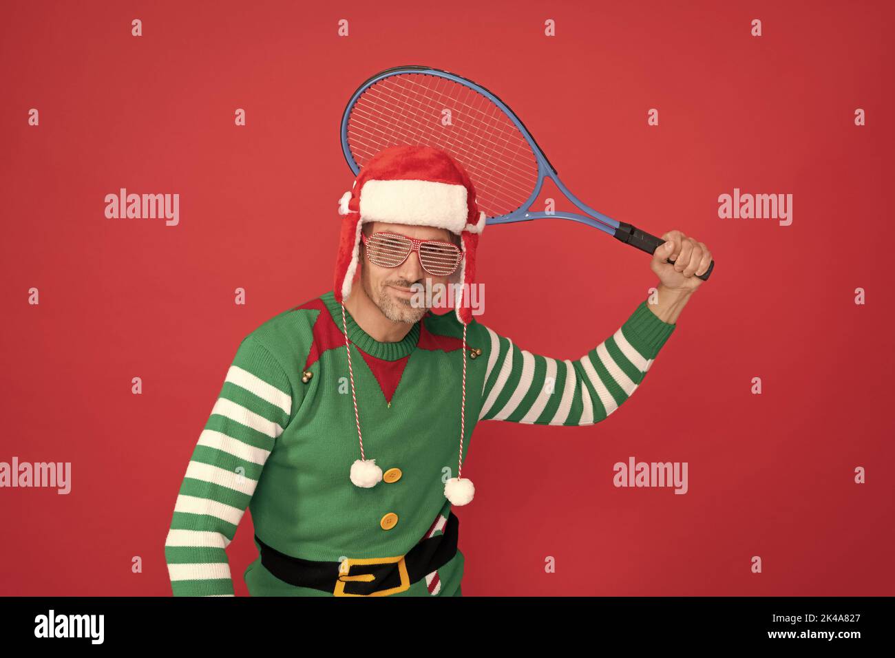 xmas guy hold tennis rocket on red background. happy new year. merry ...