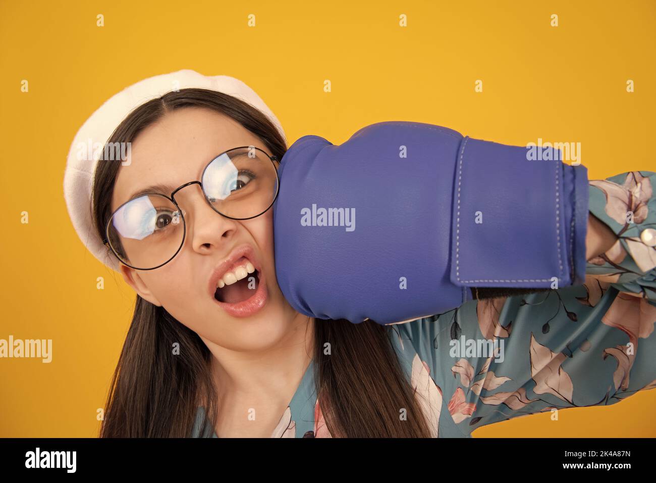 Funny face. Fun portrait of girl child in boxing gloves with punching ...