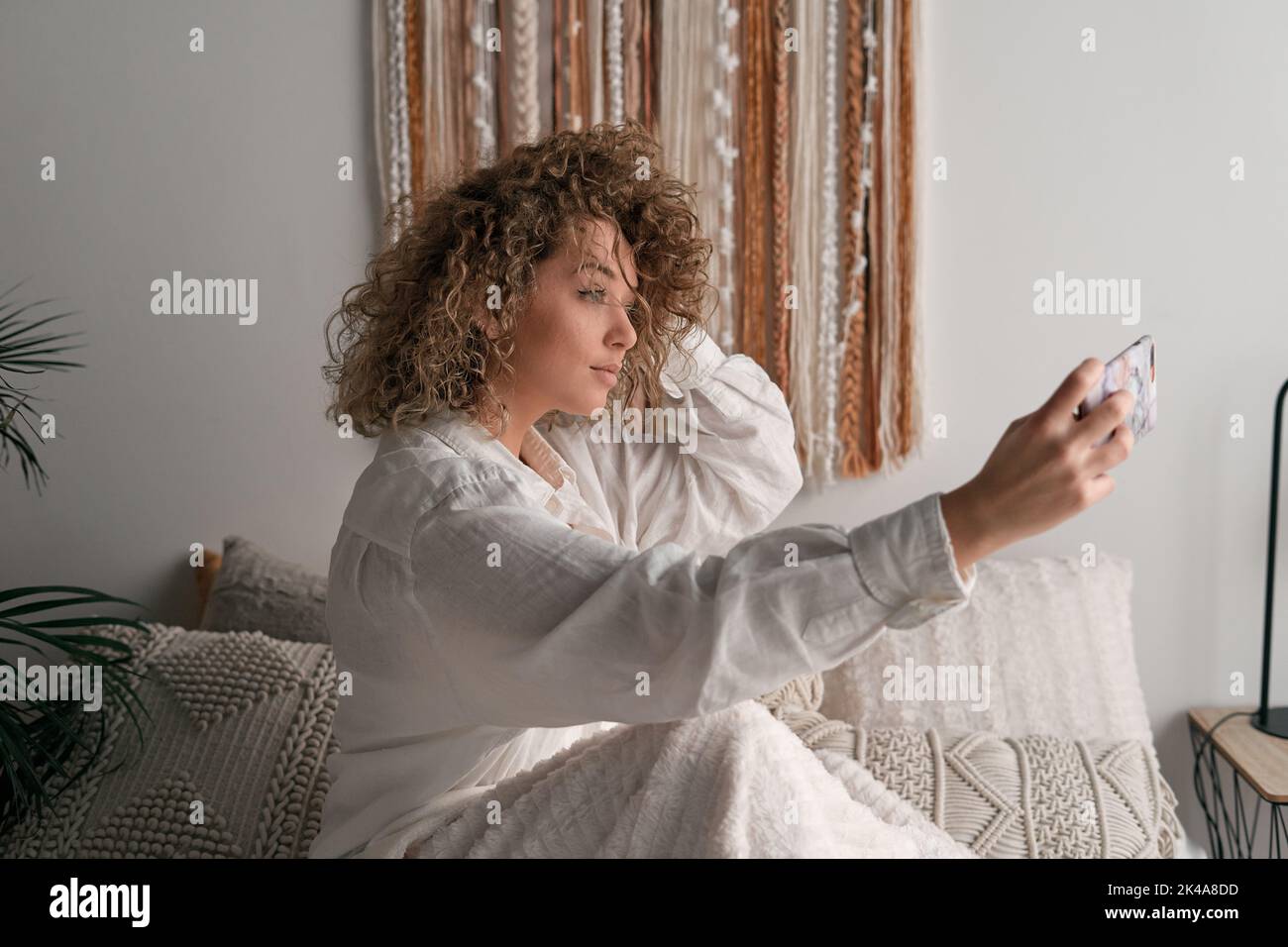 Woman taking selfie while chilling on bed Stock Photo - Alamy