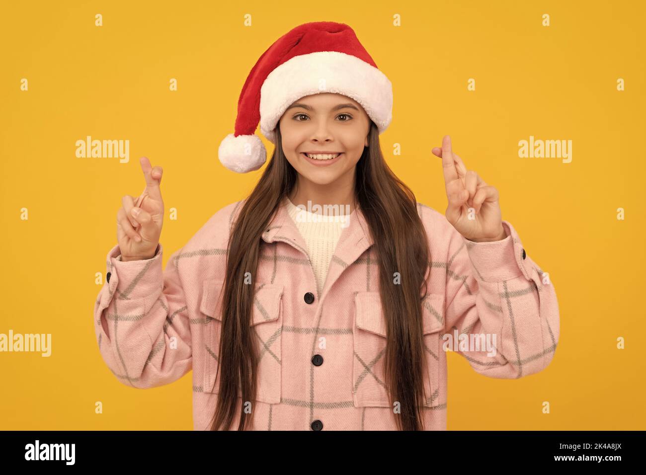 merry christmas. smiling kid in santa claus hat crossed fingers for ...
