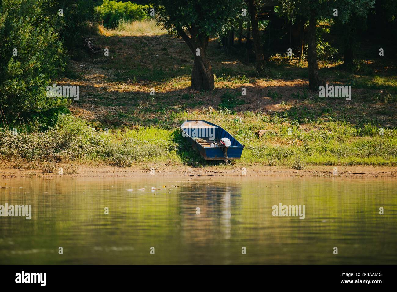An old kayak parked on a coast with green trees Stock Photo - Alamy