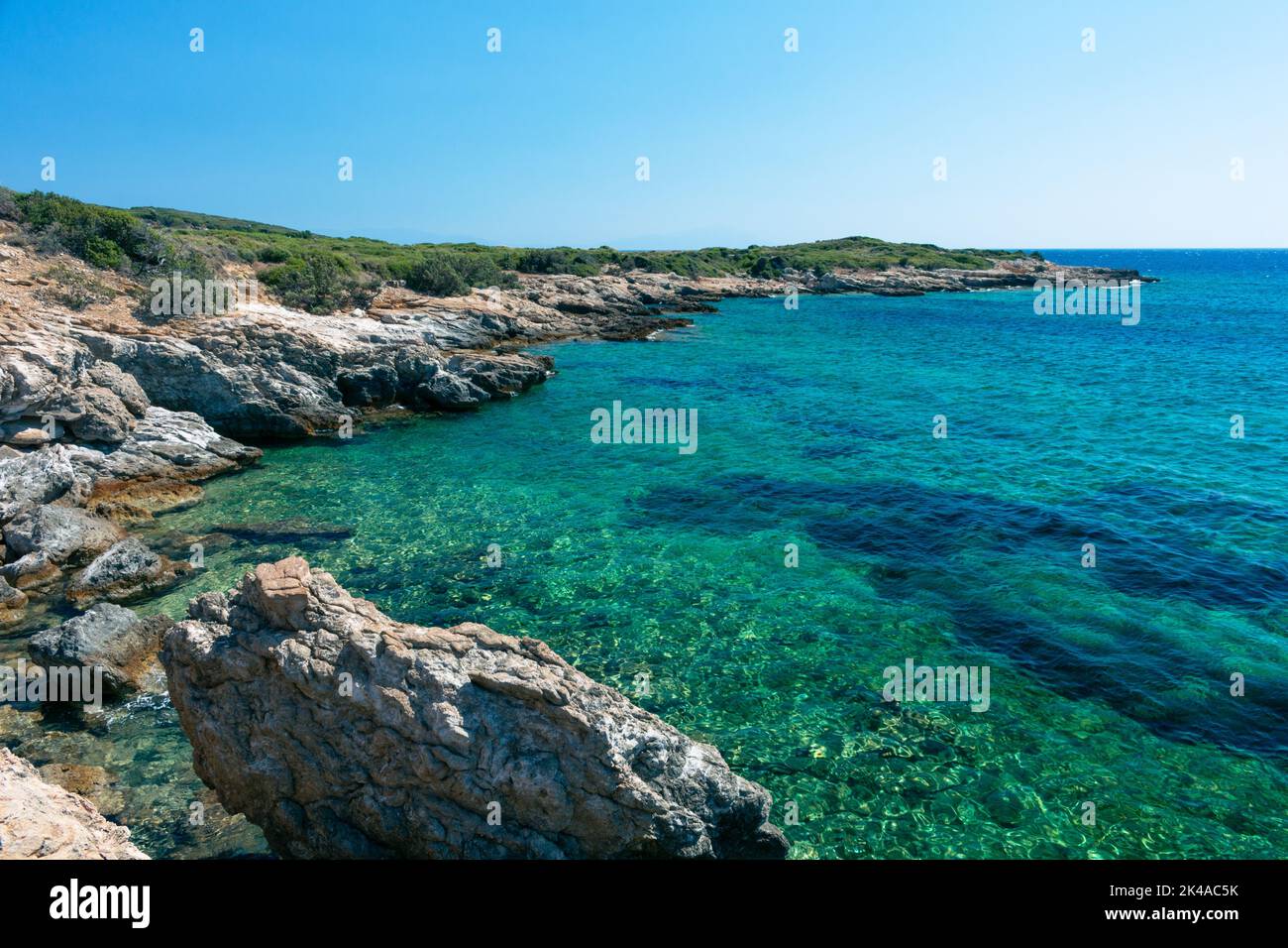 A rocky cliff near the clear blue sea water Stock Photo - Alamy