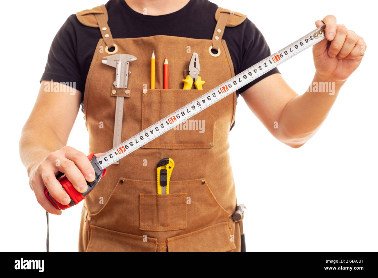 Carpenter in workers apron is holding measuring tape on white ...