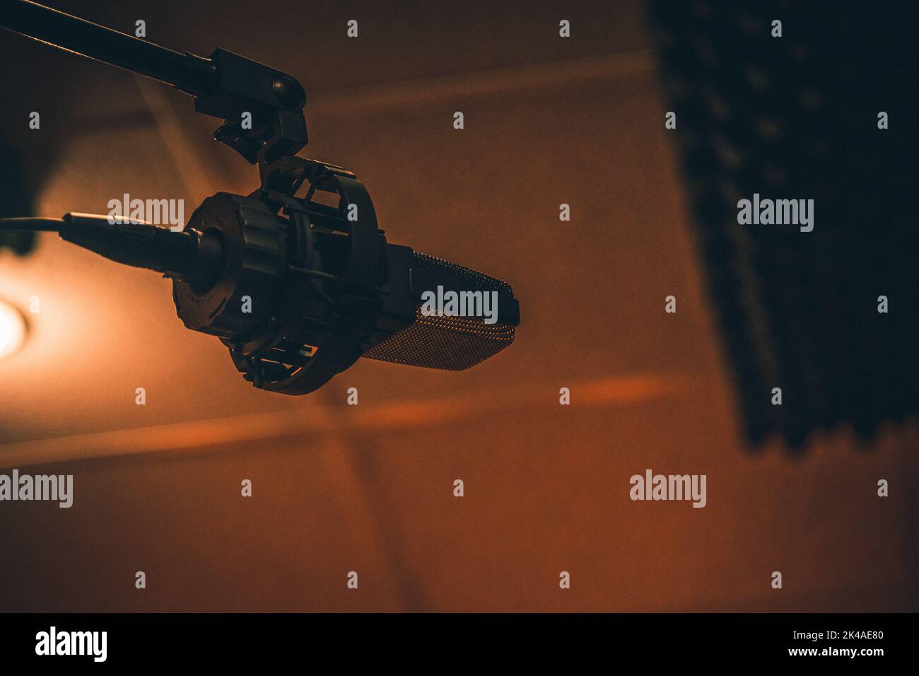 A condenser microphone hanging on a stand in a recording room Stock ...