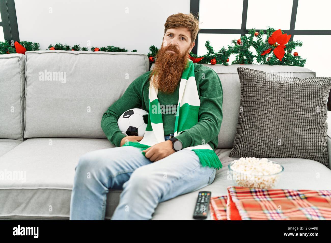 Redhead man with long beard football hooligan holding ball sitting on ...