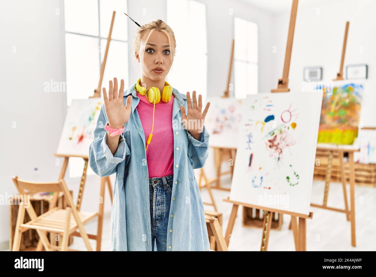 Young caucasian girl at art studio moving away hands palms showing ...
