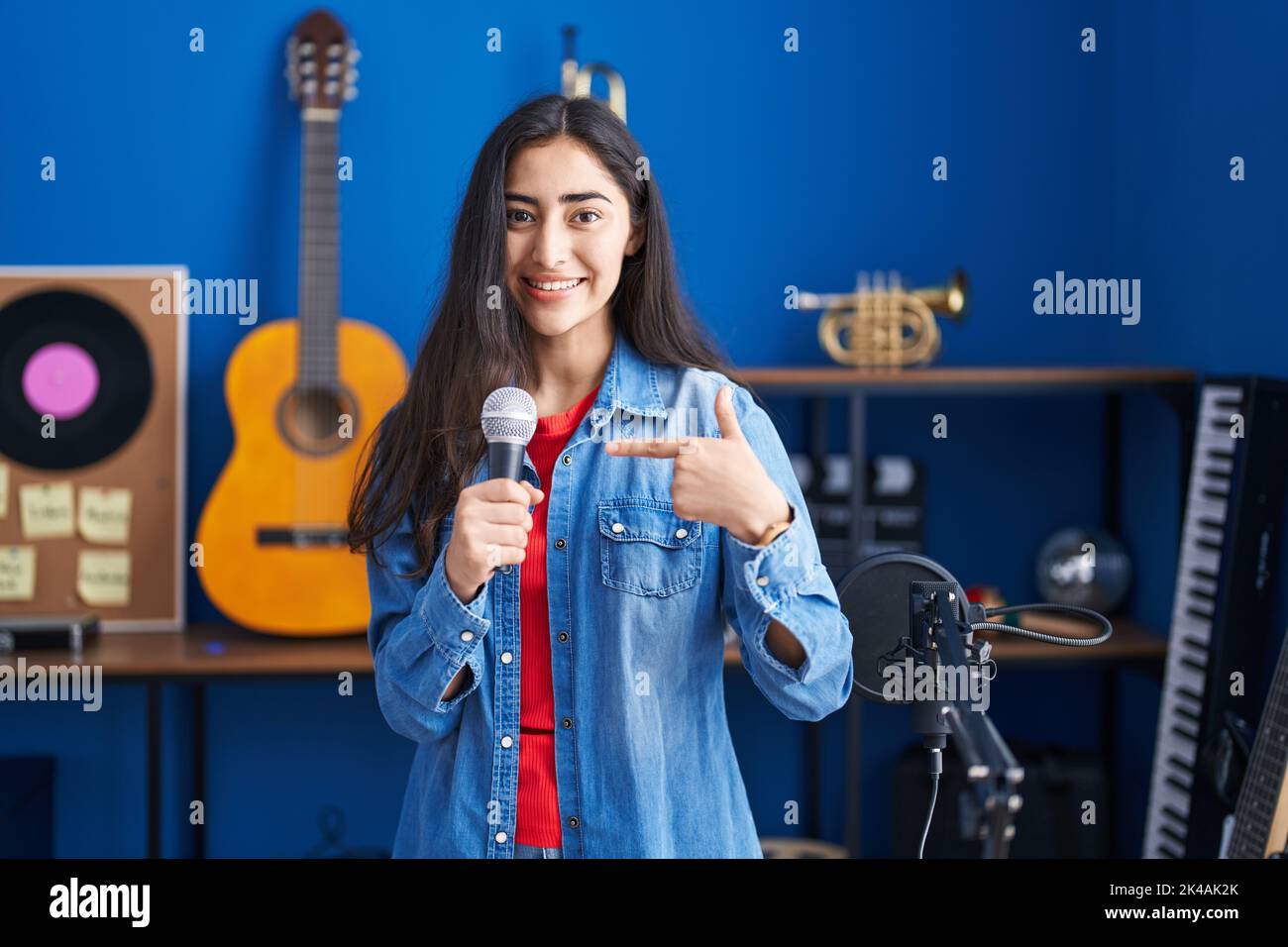 Young teenager girl singing song using microphone smiling happy ...