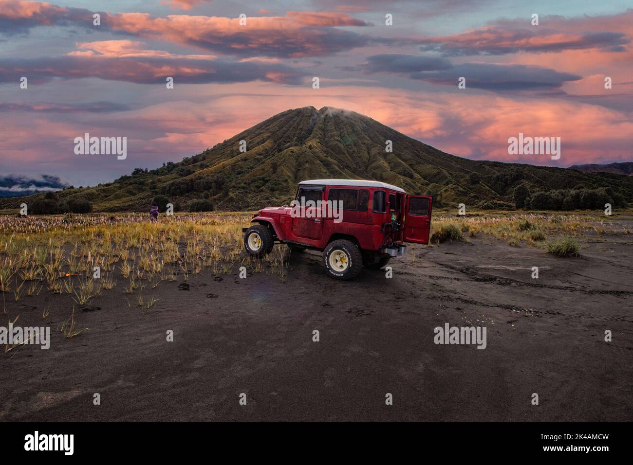 An old red off-road Jeep truck in Indonesia with Mount Bromo under a ...