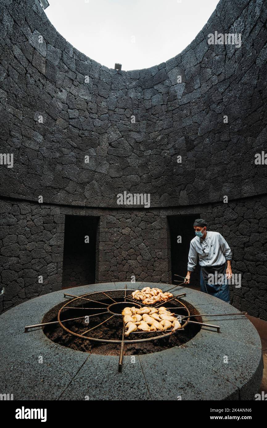 Timanfaya National Park, Spain, April 24, 2022: Cook grilling chicken ...