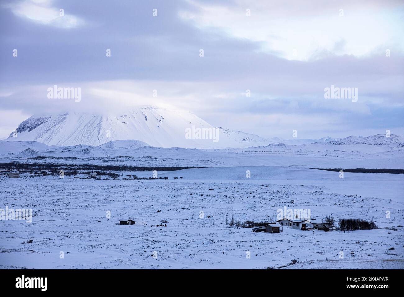 Snow-covered extinct volcano Hverfjall, lonely farmhouse in front, near ...