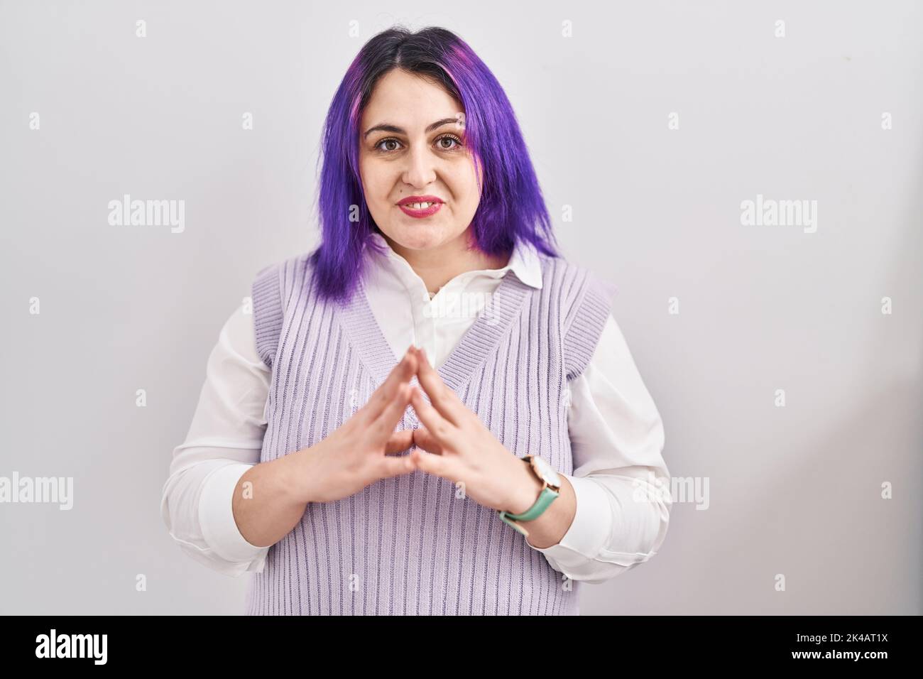 Plus size woman wit purple hair standing over white background hands ...