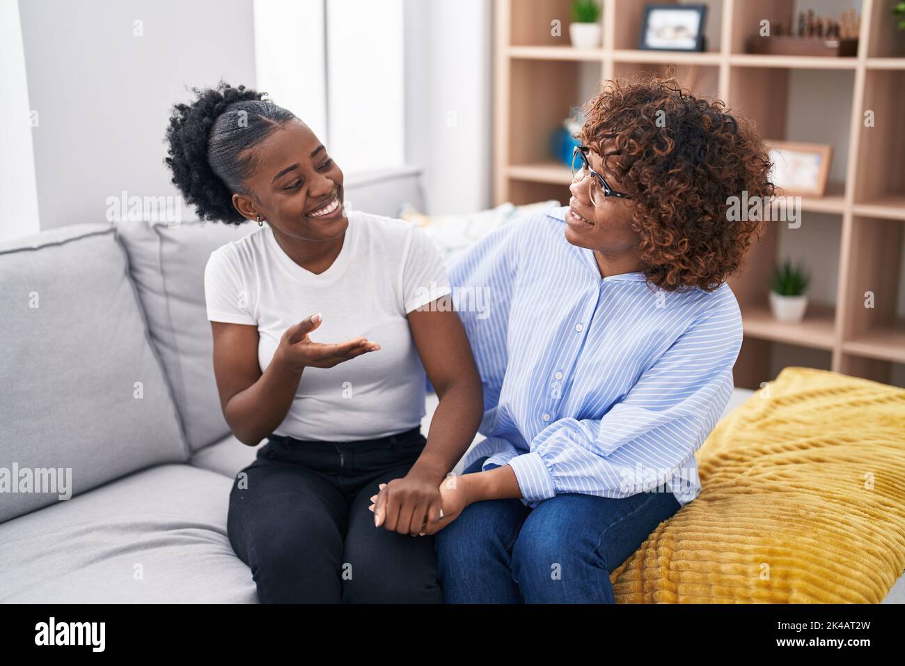 African american women mother and daughter sitting together on sofa at home Stock Photo - Alamy