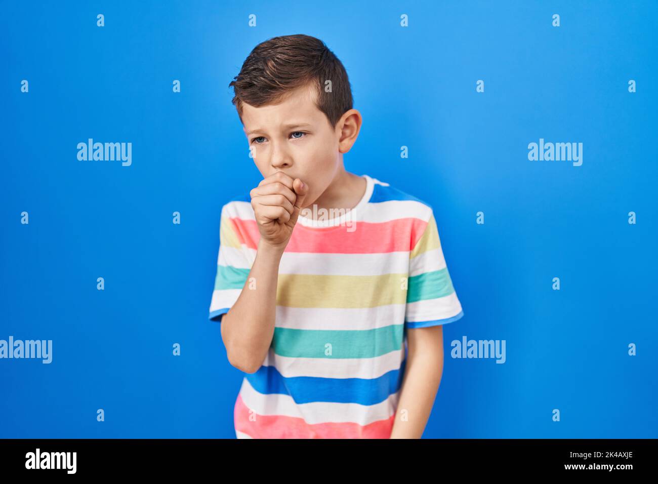 Young caucasian kid standing over blue background feeling unwell and ...