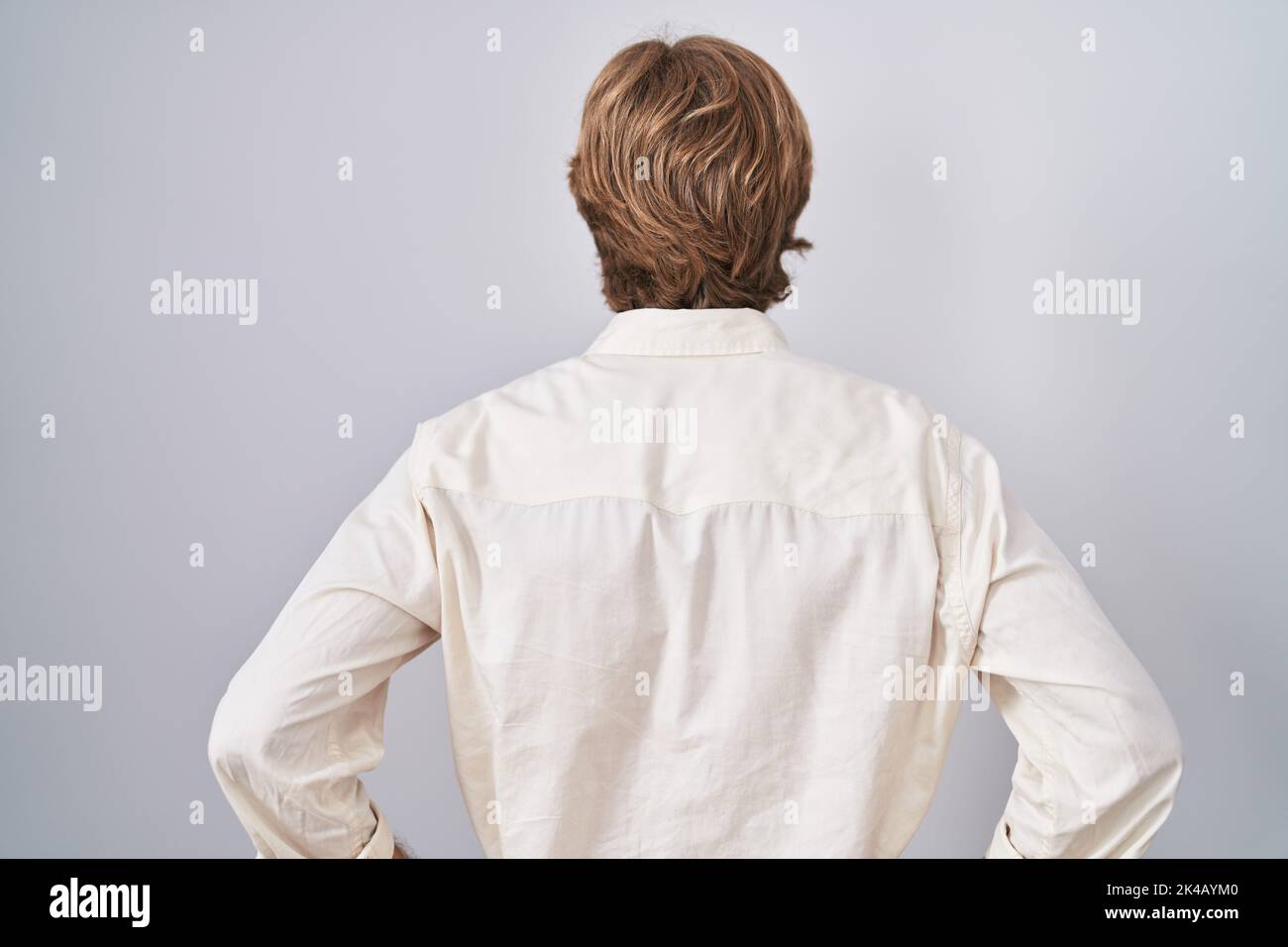 Middle age man standing over isolated background standing backwards ...