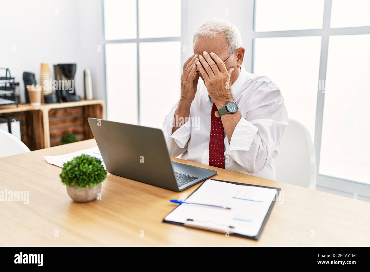 Senior man working at the office using computer laptop with sad ...