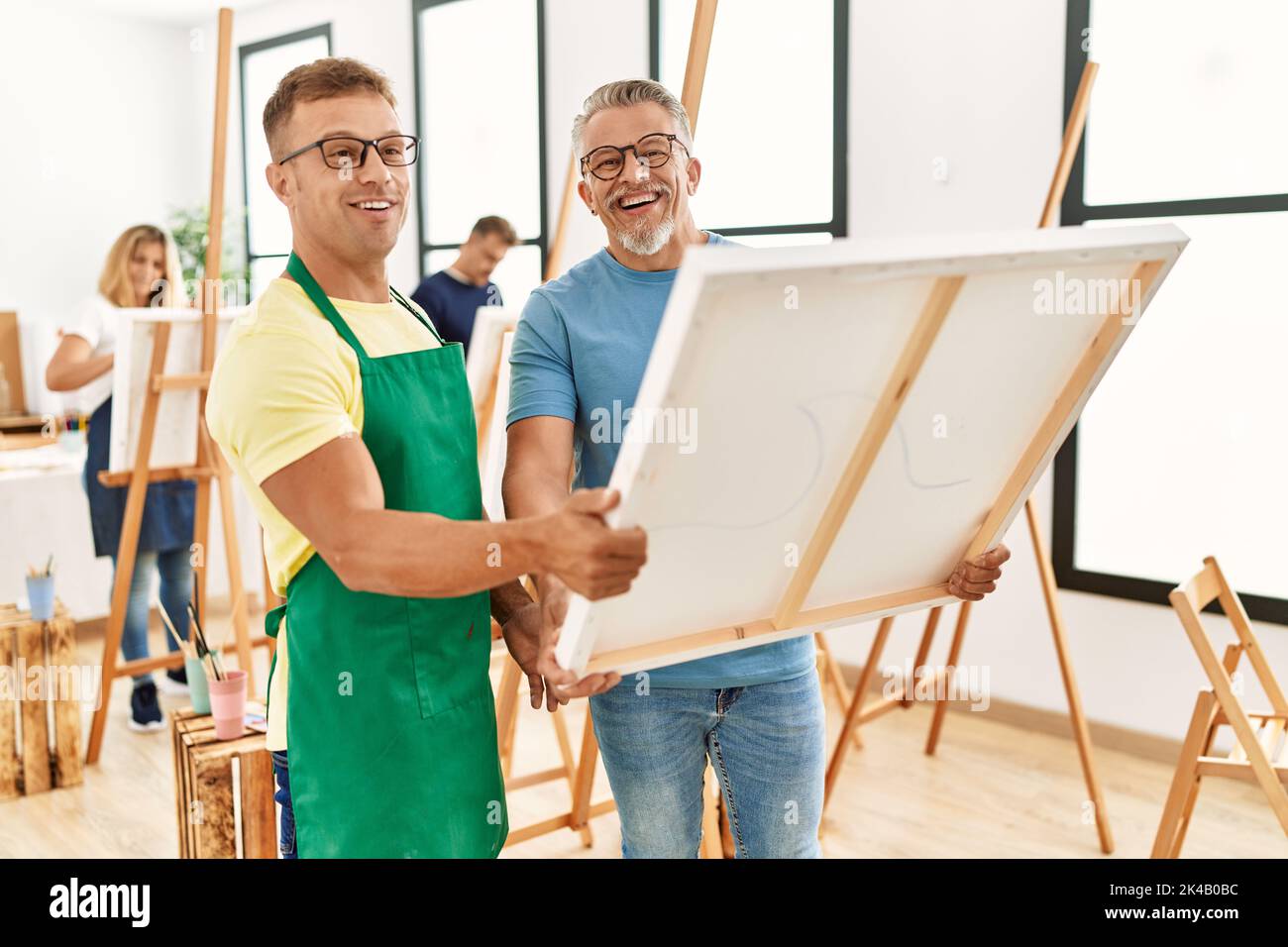 Group of middle age people drawing at art studio. Two students smiling ...