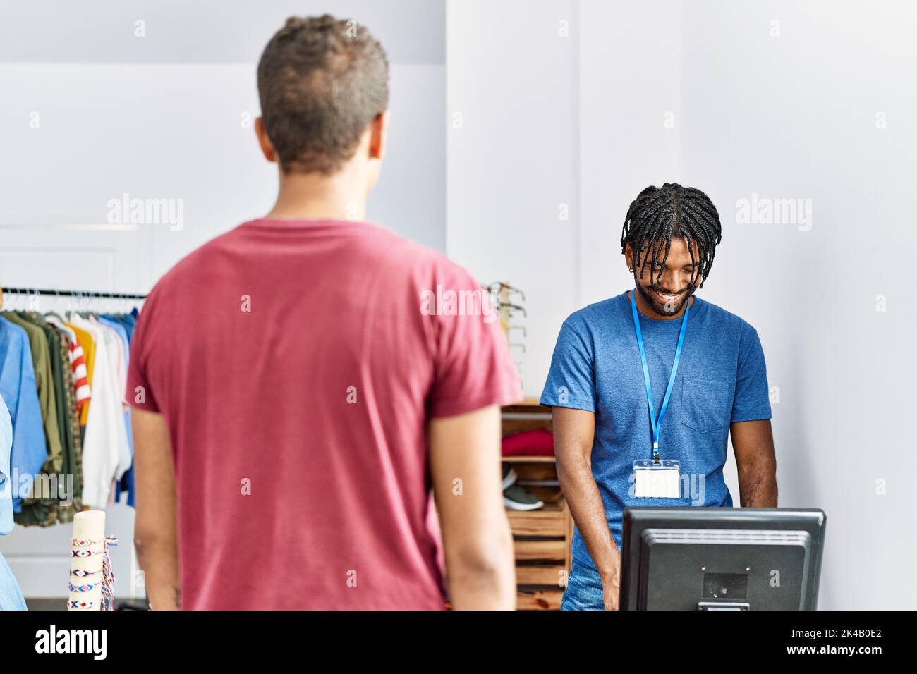 Two men shopkeeper and customer standing at clothing store Stock Photo ...