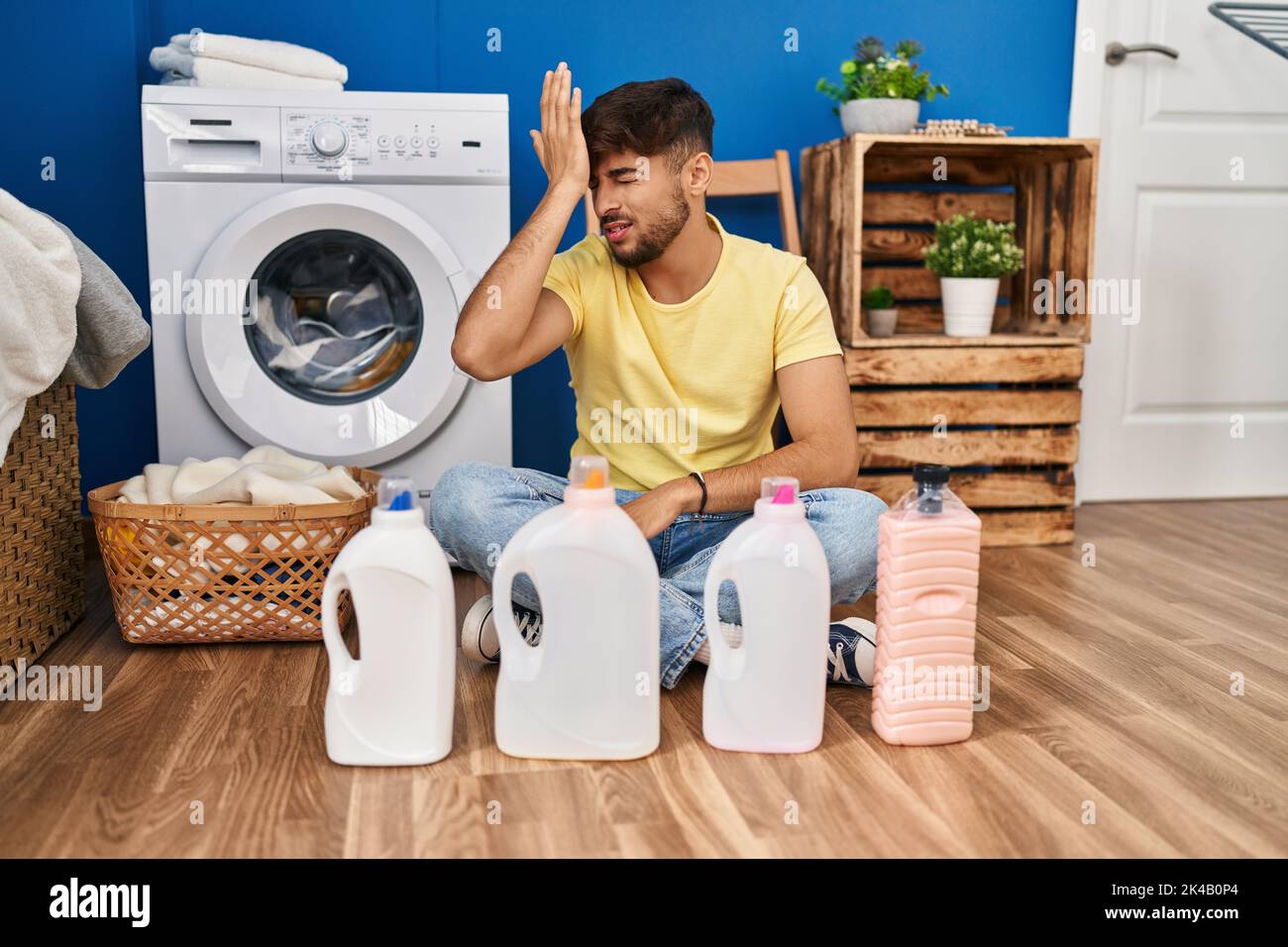 Arab man with beard doing laundry sitting on the floor with detergent ...