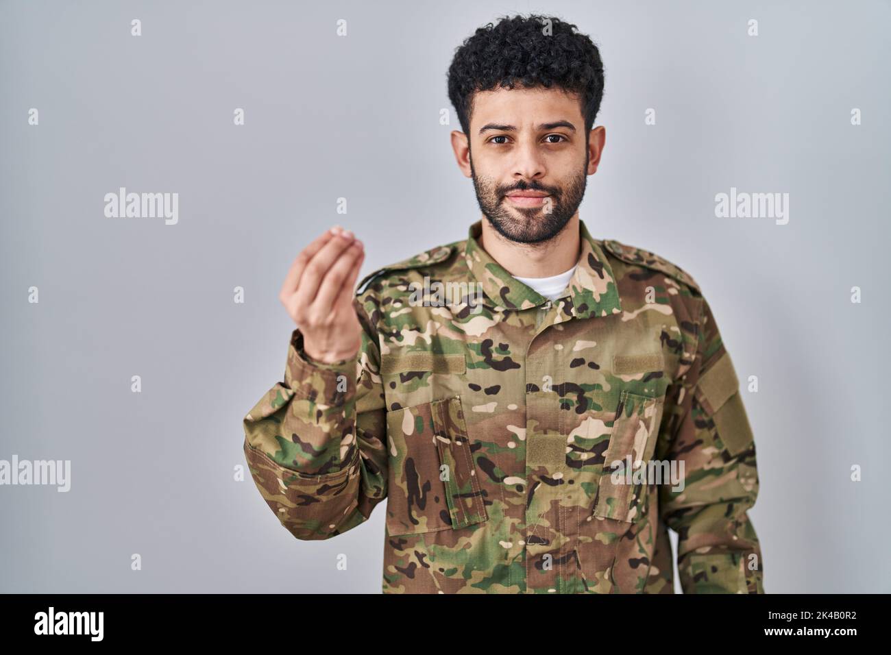Arab man wearing camouflage army uniform doing italian gesture with ...