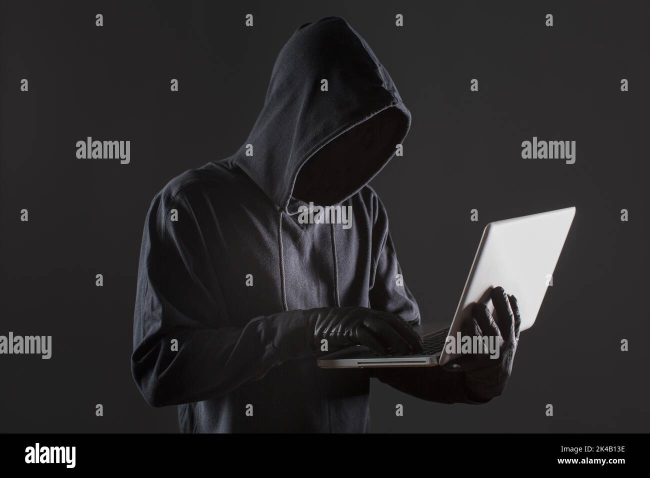 Side view of male hacker with gloves and laptop. Resolution and high ...