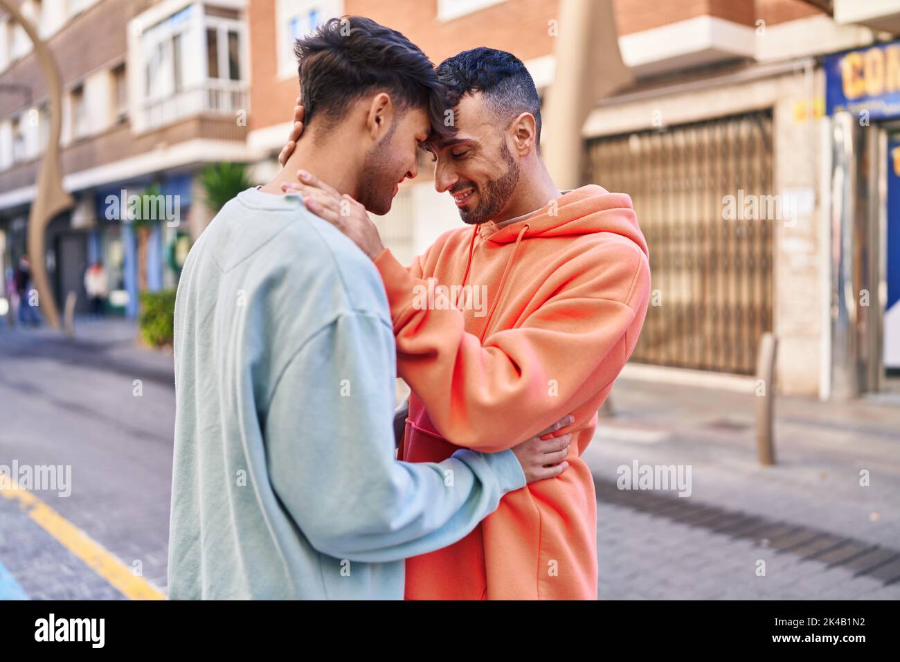 Two man couple hugging each other standing at street Stock Photo - Alamy
