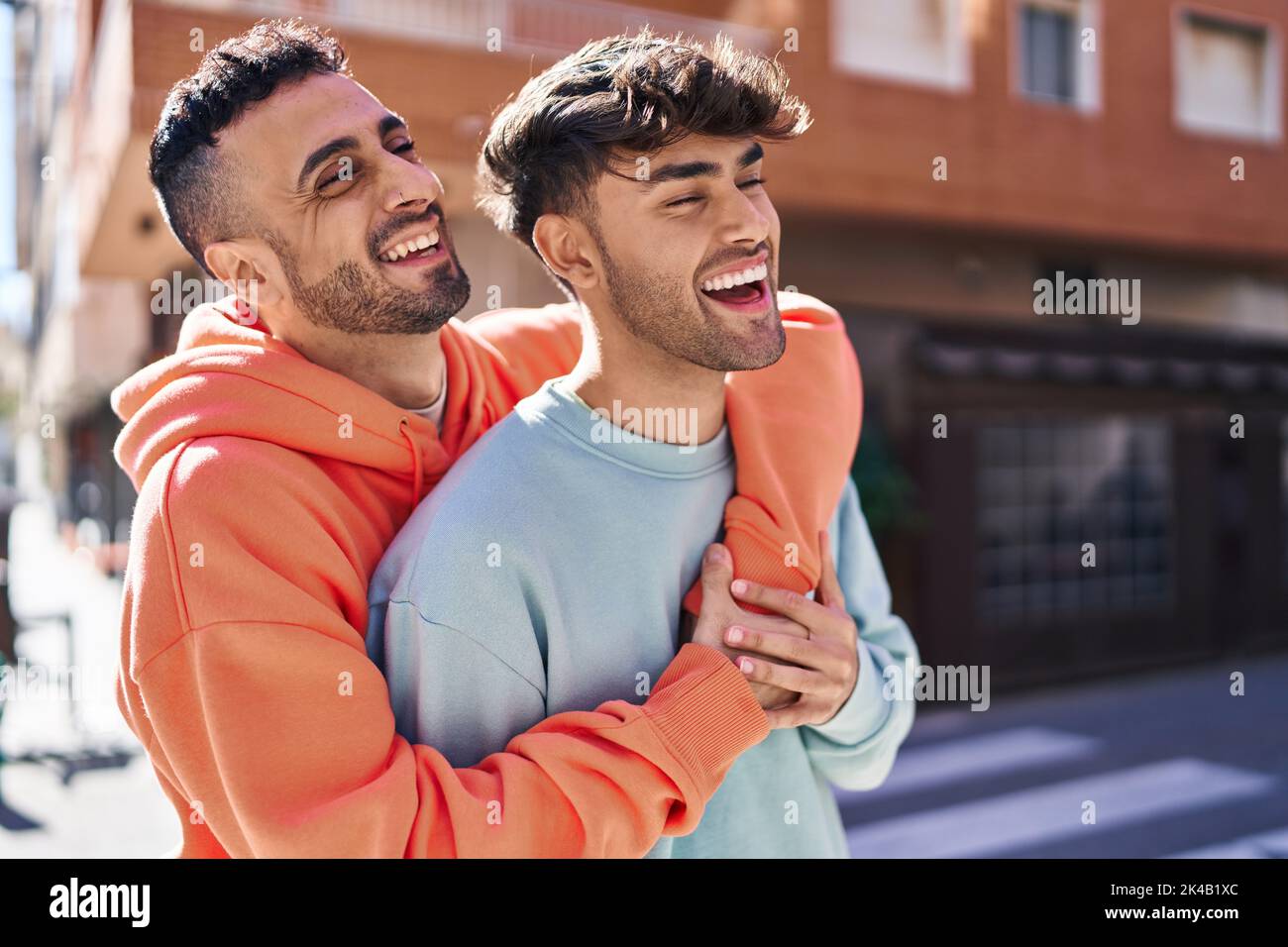 Two man couple hugging each other standing at street Stock Photo - Alamy