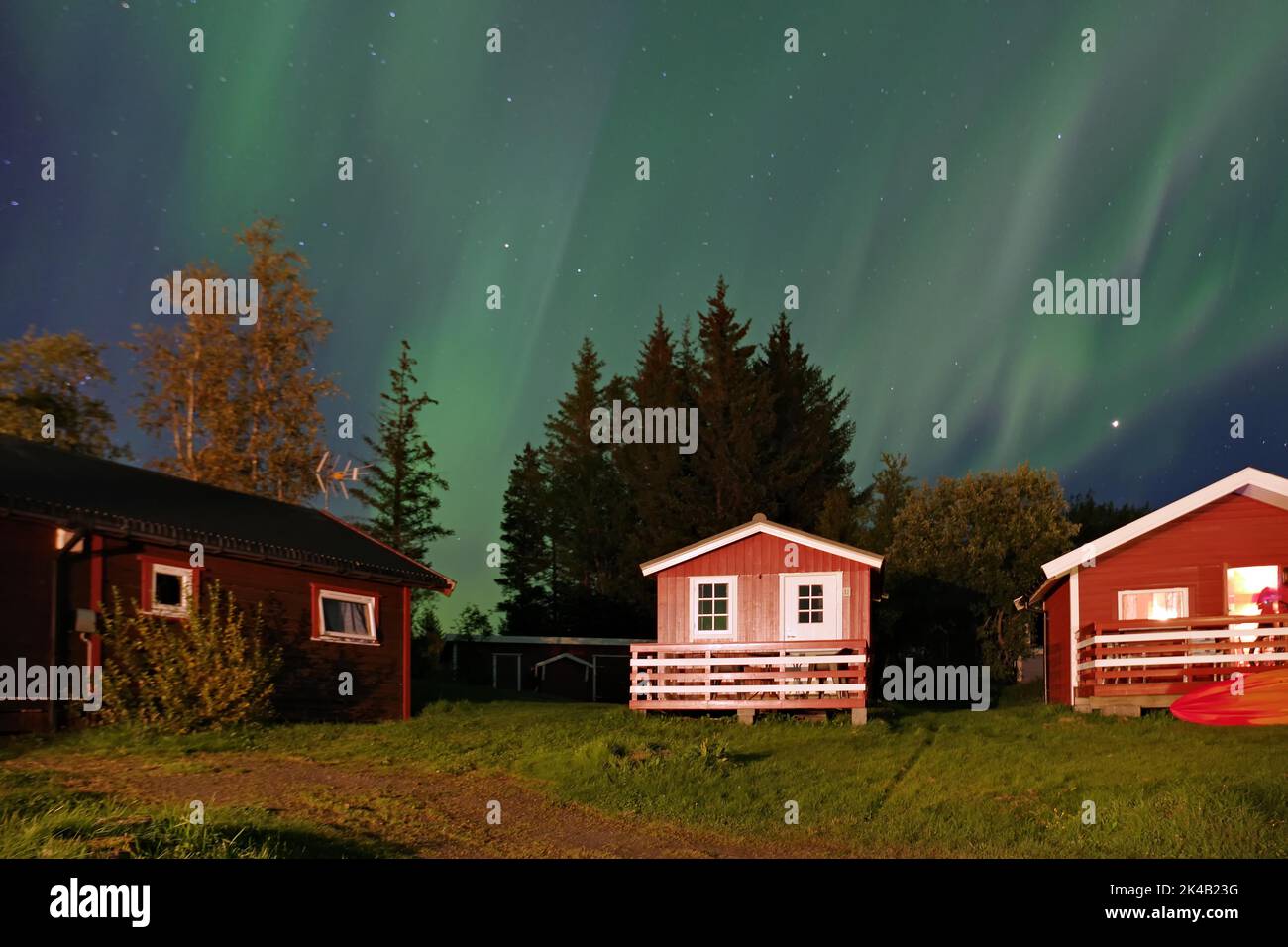 Small, red wooden holiday cabins, northern lights (aurora borealis ...