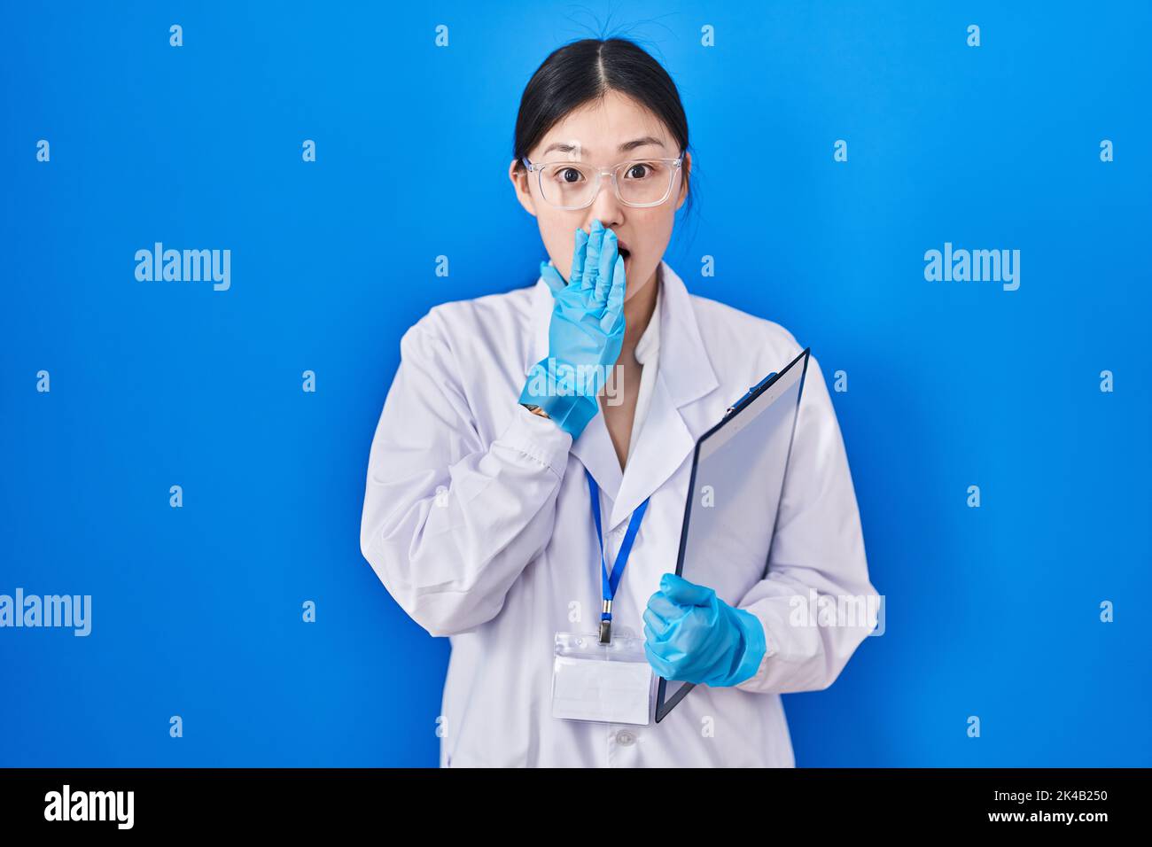 Chinese young woman working at scientist laboratory afraid and shocked ...