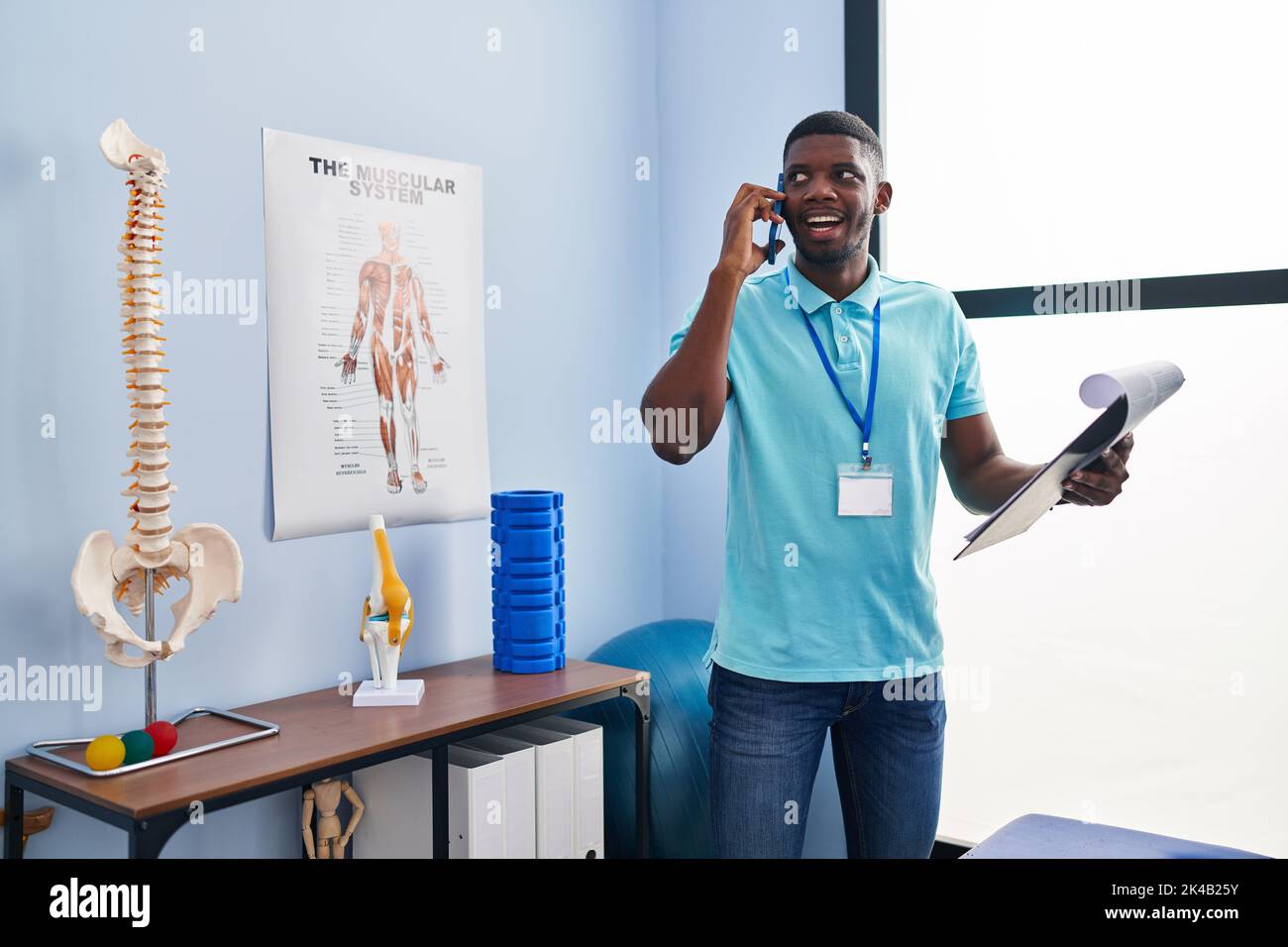 Young african american man physiotherapist talking on the smartphone al ...
