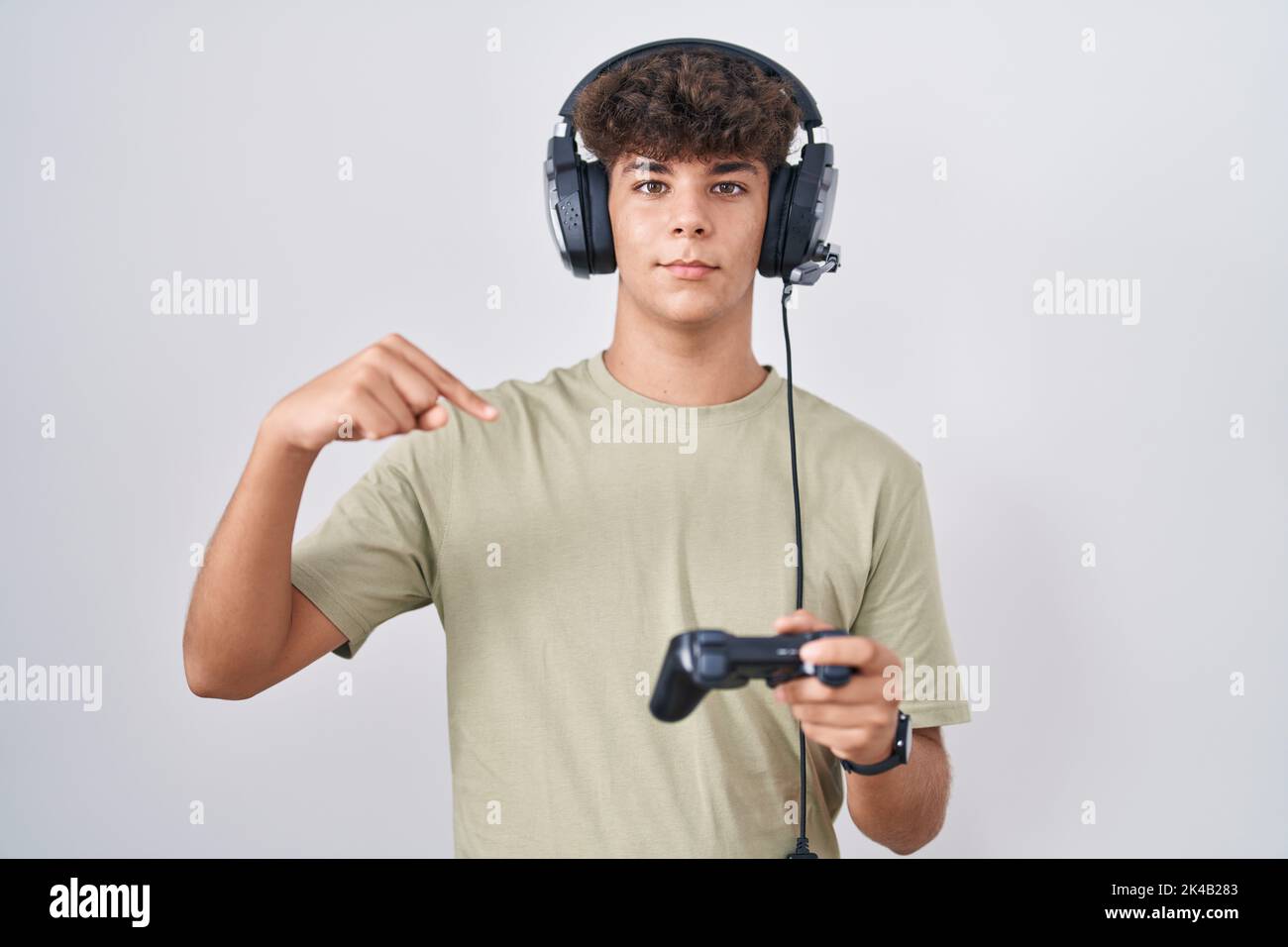 Hispanic teenager playing video game holding controller looking ...