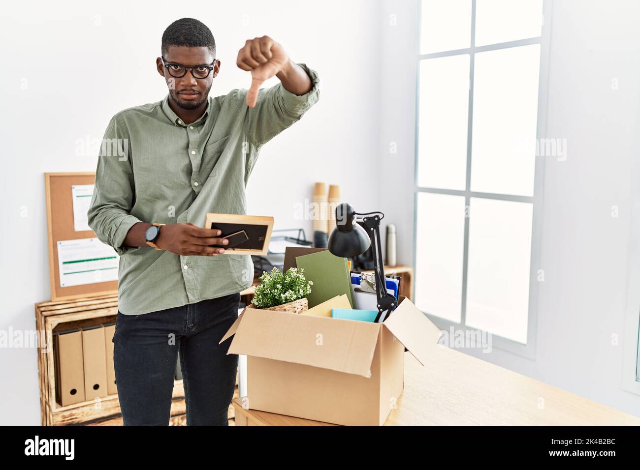 Young african american businessman unboxing box at the office looking ...