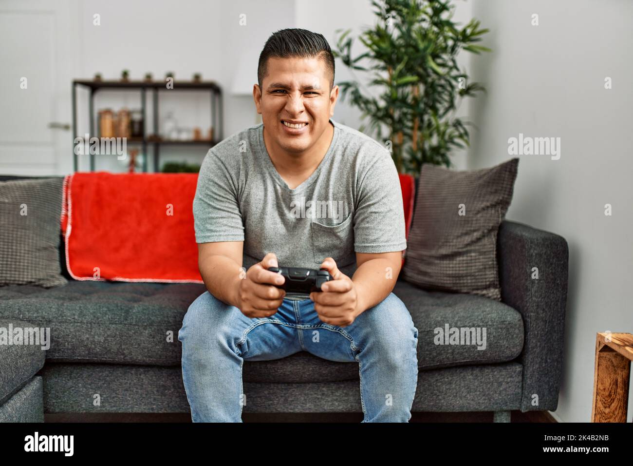 Young hispanic man angry playing video game at home Stock Photo - Alamy