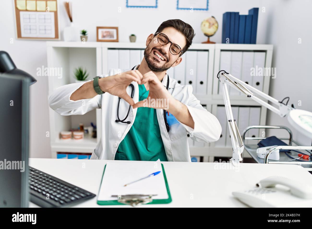 Young man with beard wearing doctor uniform and stethoscope at the ...