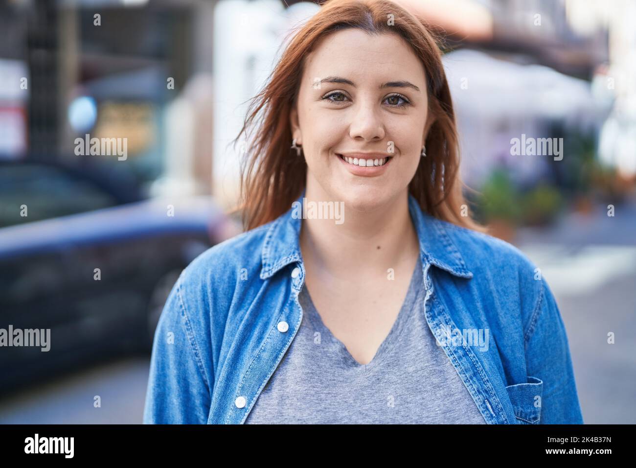 Young beautiful plus size woman smiling confident standing at street ...