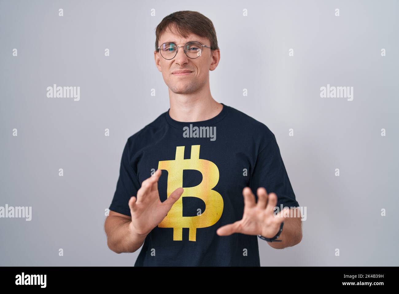 Caucasian blond man wearing bitcoin t shirt disgusted expression ...