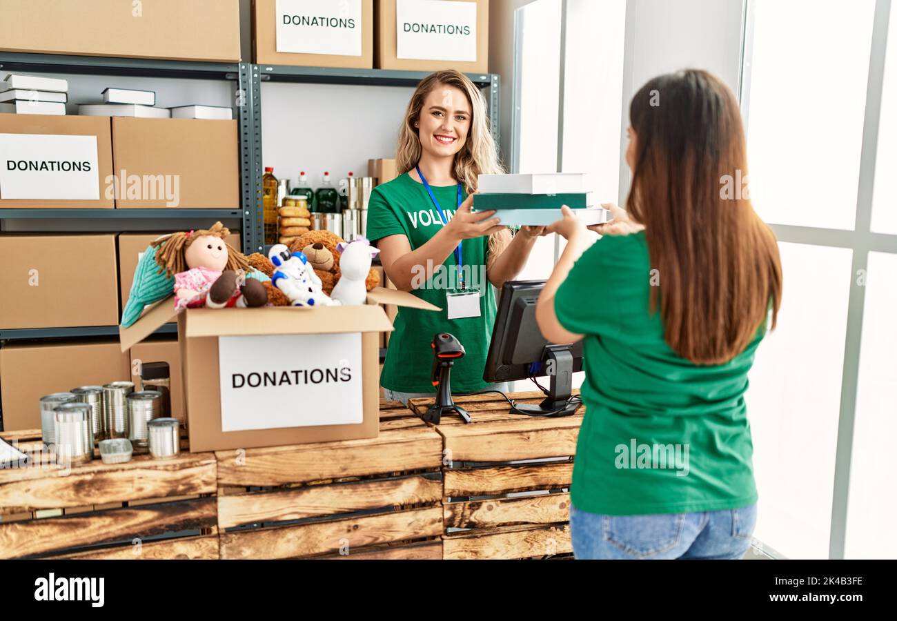 Young volunteer girl helping woman at charity center Stock Photo - Alamy