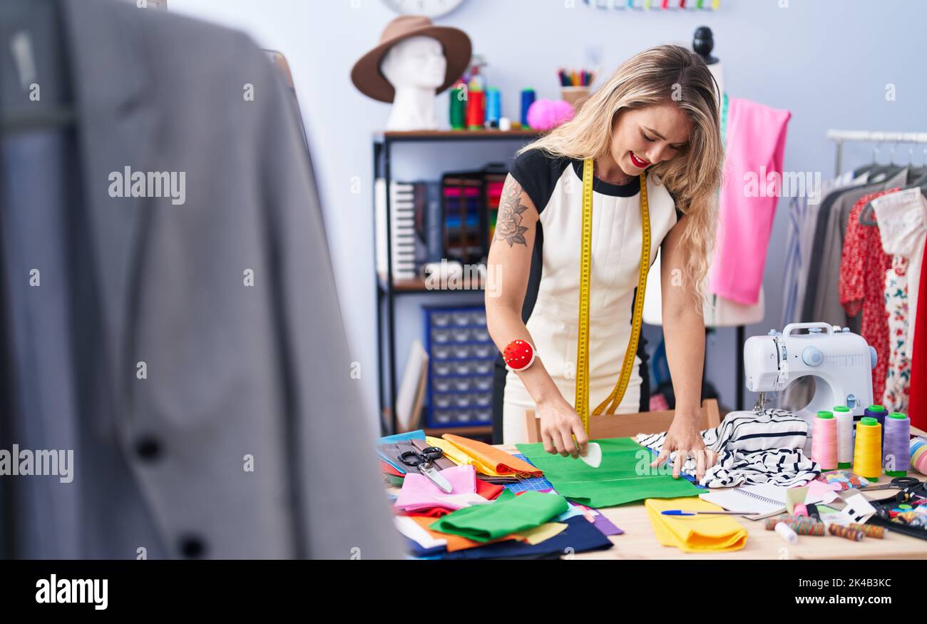 Young beautiful hispanic woman tailor smiling confident make mark on ...